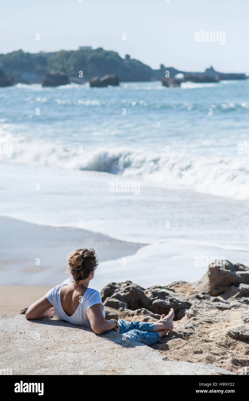 Woman sunbathing rocks beach hi-res stock photography and images - Alamy