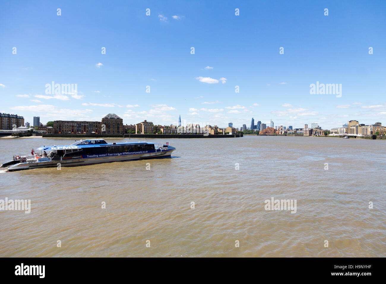 A Thames Clippers ferry travelling along the River Thames, with London ...