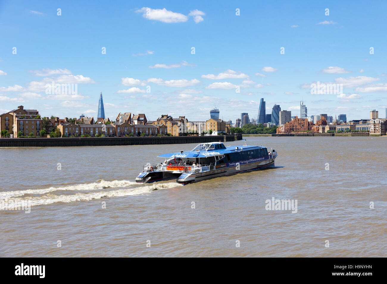 A Thames Clippers ferry travelling along the River Thames, with London ...