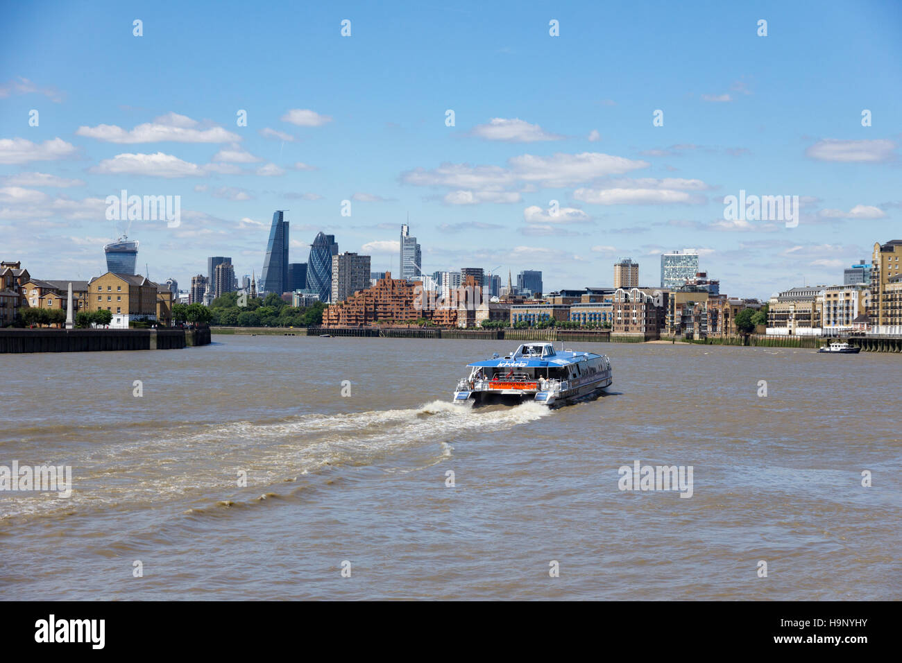 A Thames Clippers ferry travelling along the River Thames, with London ...
