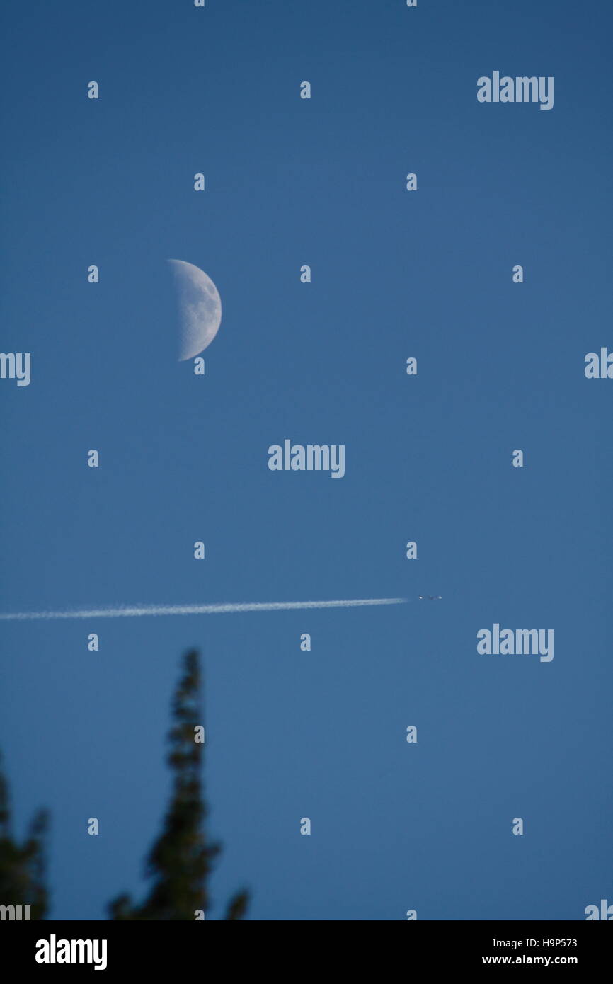 Plane flying by Moon Stock Photo - Alamy
