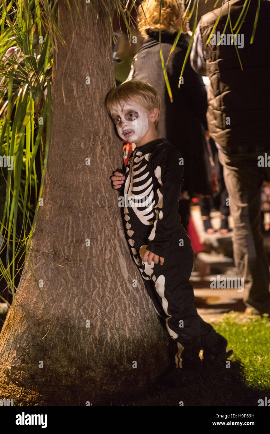 A young boy dressed in a skeleton costume rests during the Day of the ...