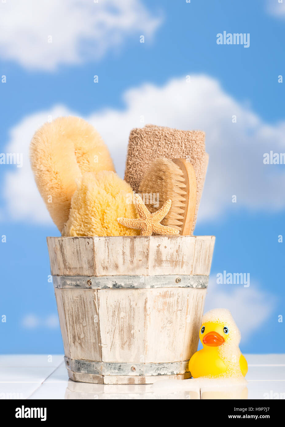 Bucket filled with bathroom objects with rubber duck covered in soap ...
