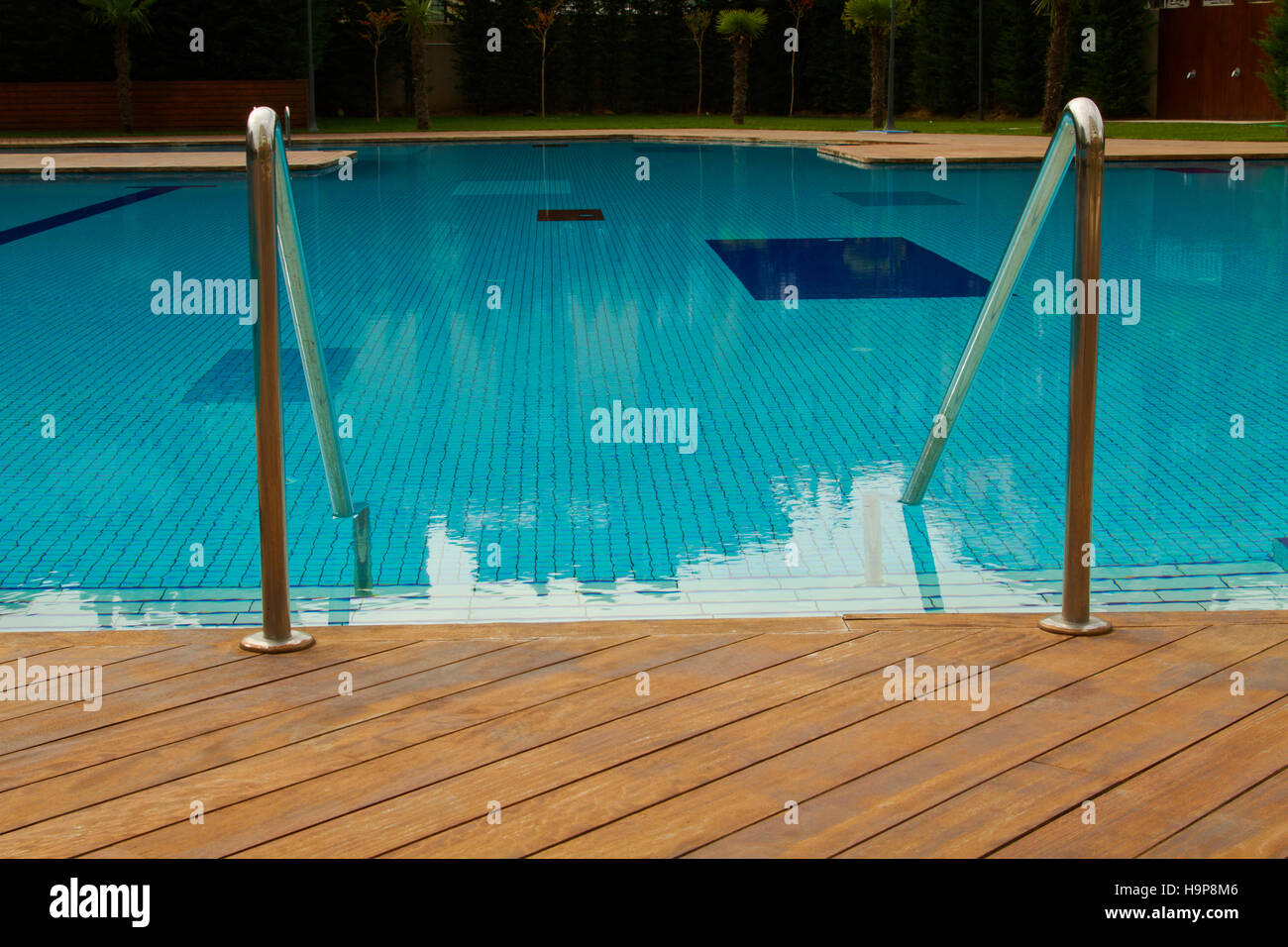 Swimming pool with old wooden flooring and blue water Stock Photo - Alamy