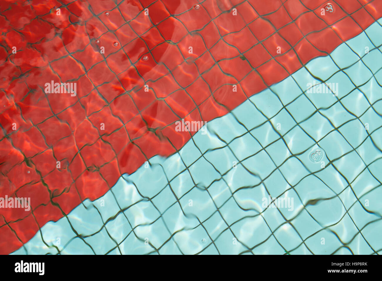 Swimming pool floor with blue and red tiles Stock Photo - Alamy