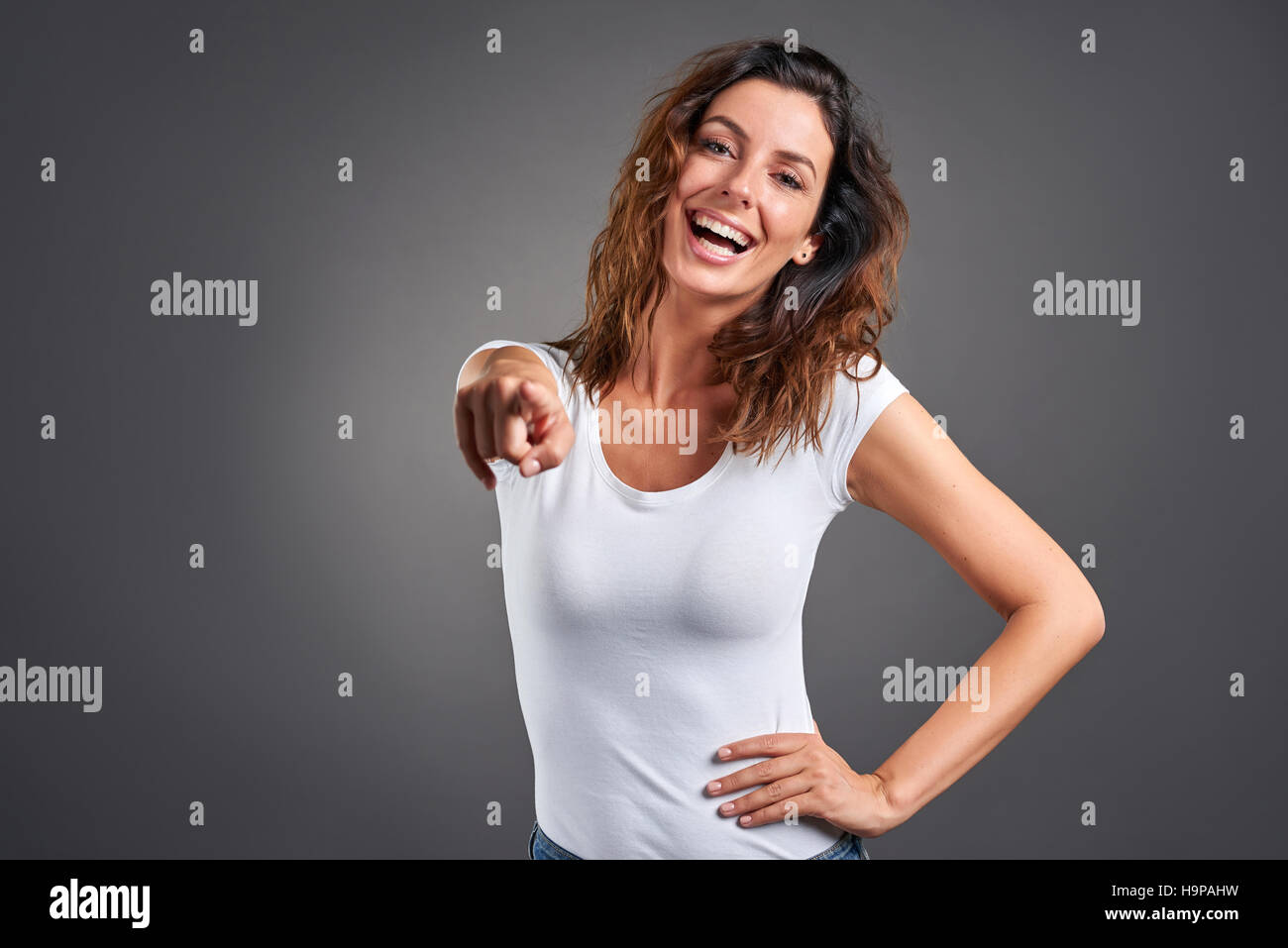 A Beautiful Young Woman Smiling And Pointing In To The Camera Stock
