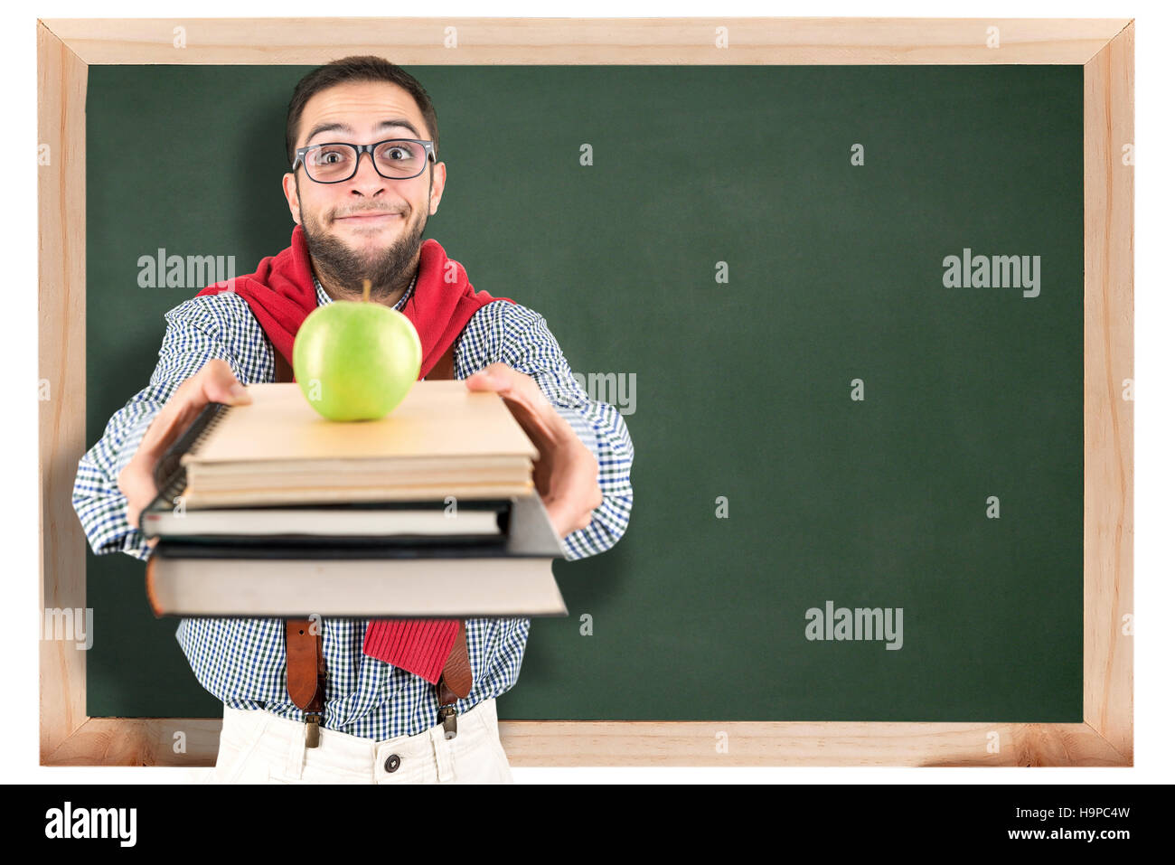 Nerd student posing with books and apple against a chalk board Stock ...