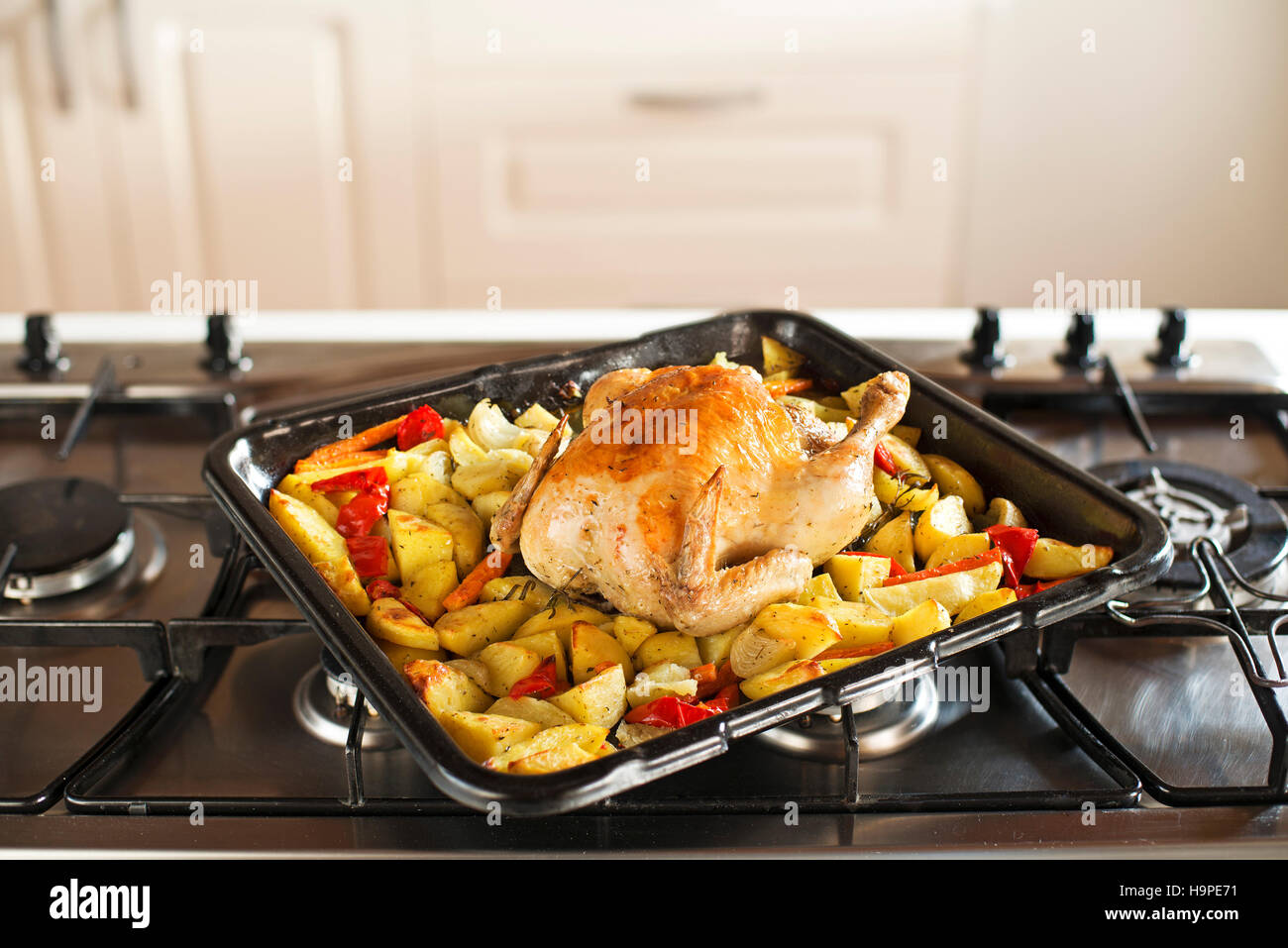 Roasted chicken with potatoes and vegetables- cooking in the oven Stock ...
