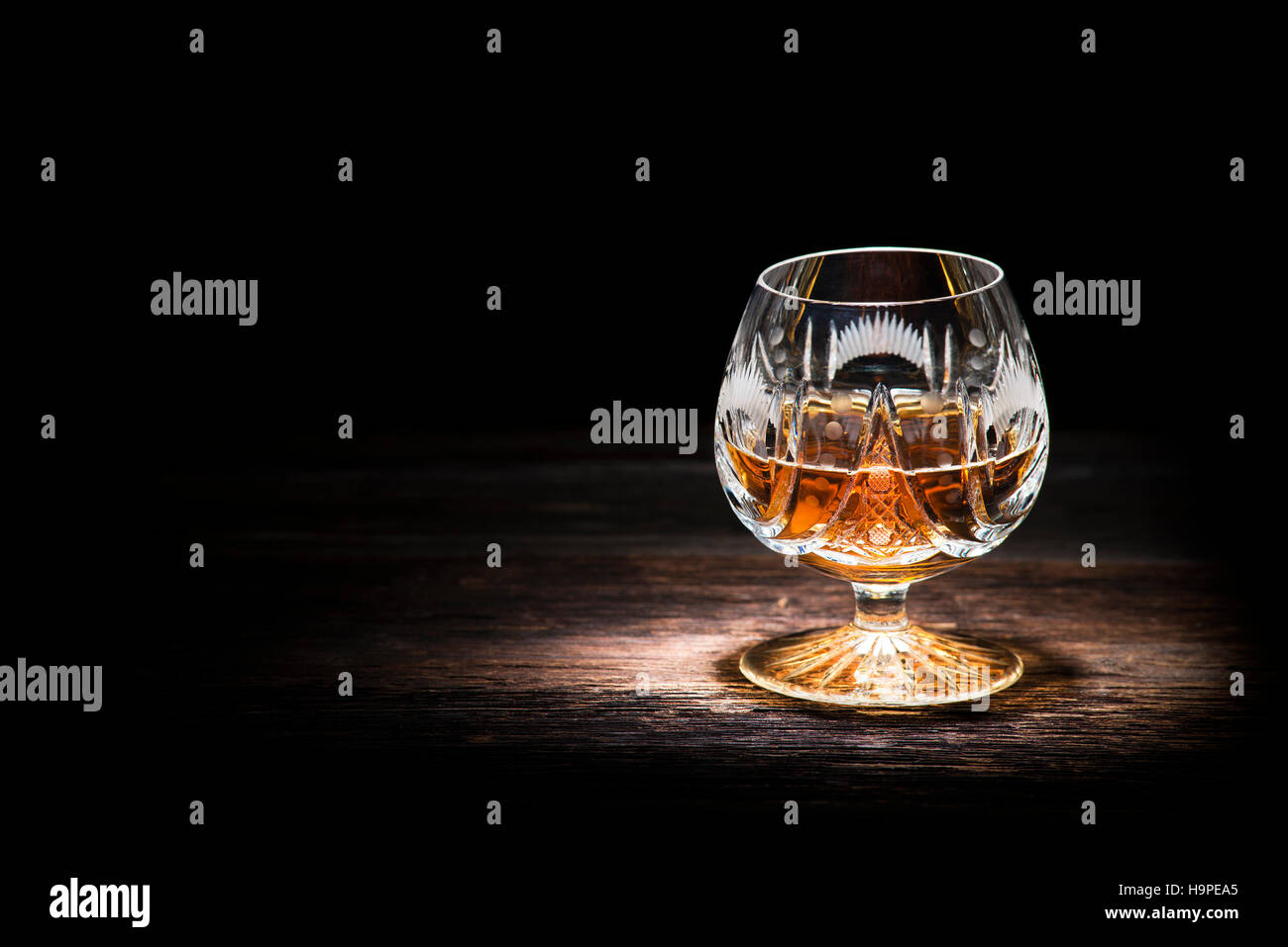 Cognac in crystal glass on wooden background Stock Photo - Alamy
