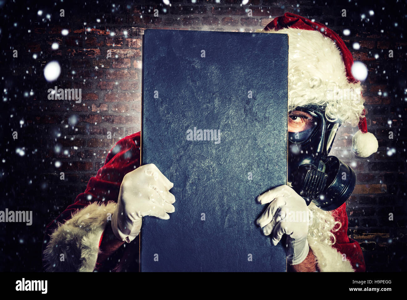 Santa Claus with gas mask holding blank chalkboard Stock Photo - Alamy