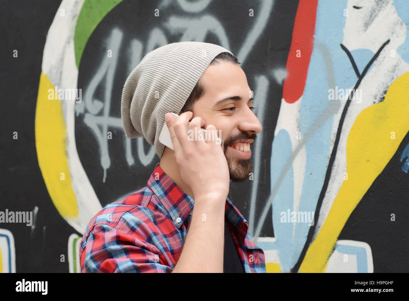 Handsome young latin man talking on the phone. Trendy and urban scene ...