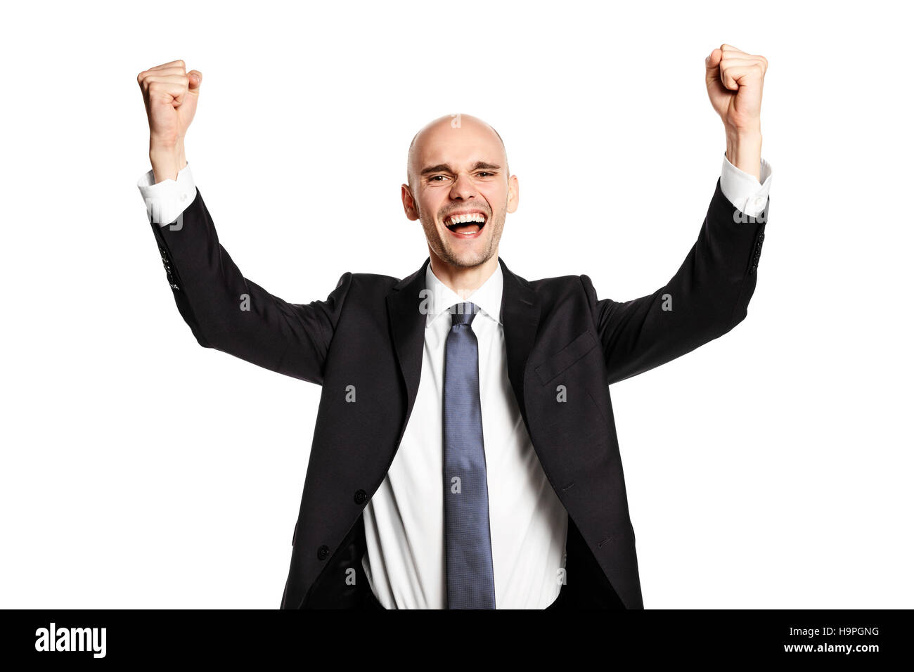Studio shot of a young man who raises his hands in a gesture of victory ...