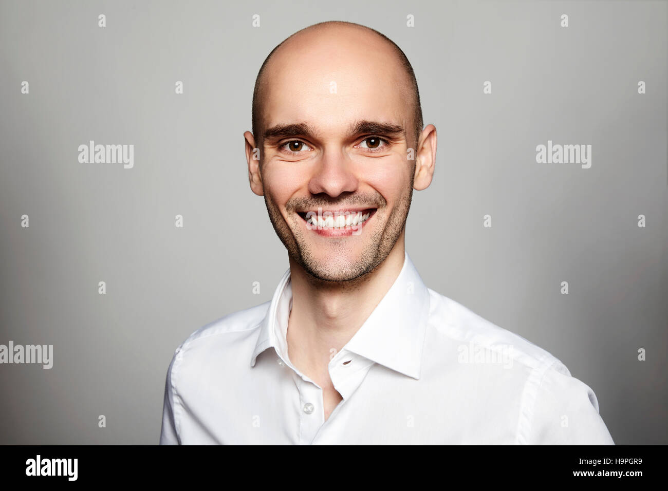 Headshot of young man smiling to the camera. Portrait on gray ...