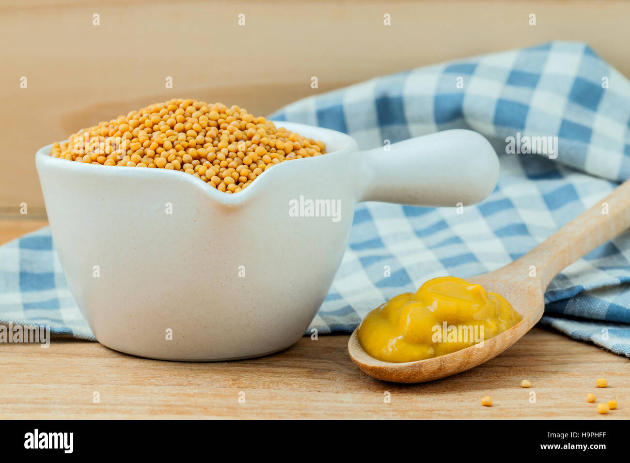 Composition of mustard in wooden spoon and mustard seeds in cera Stock ...