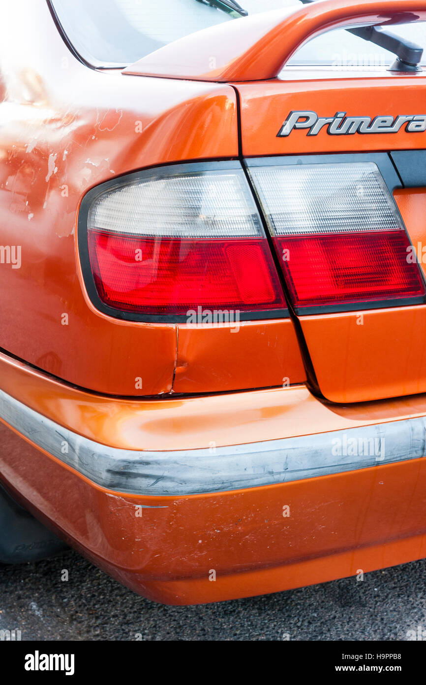 Orange Nissen Primera car. After collision. Corner of bumper and frame ...
