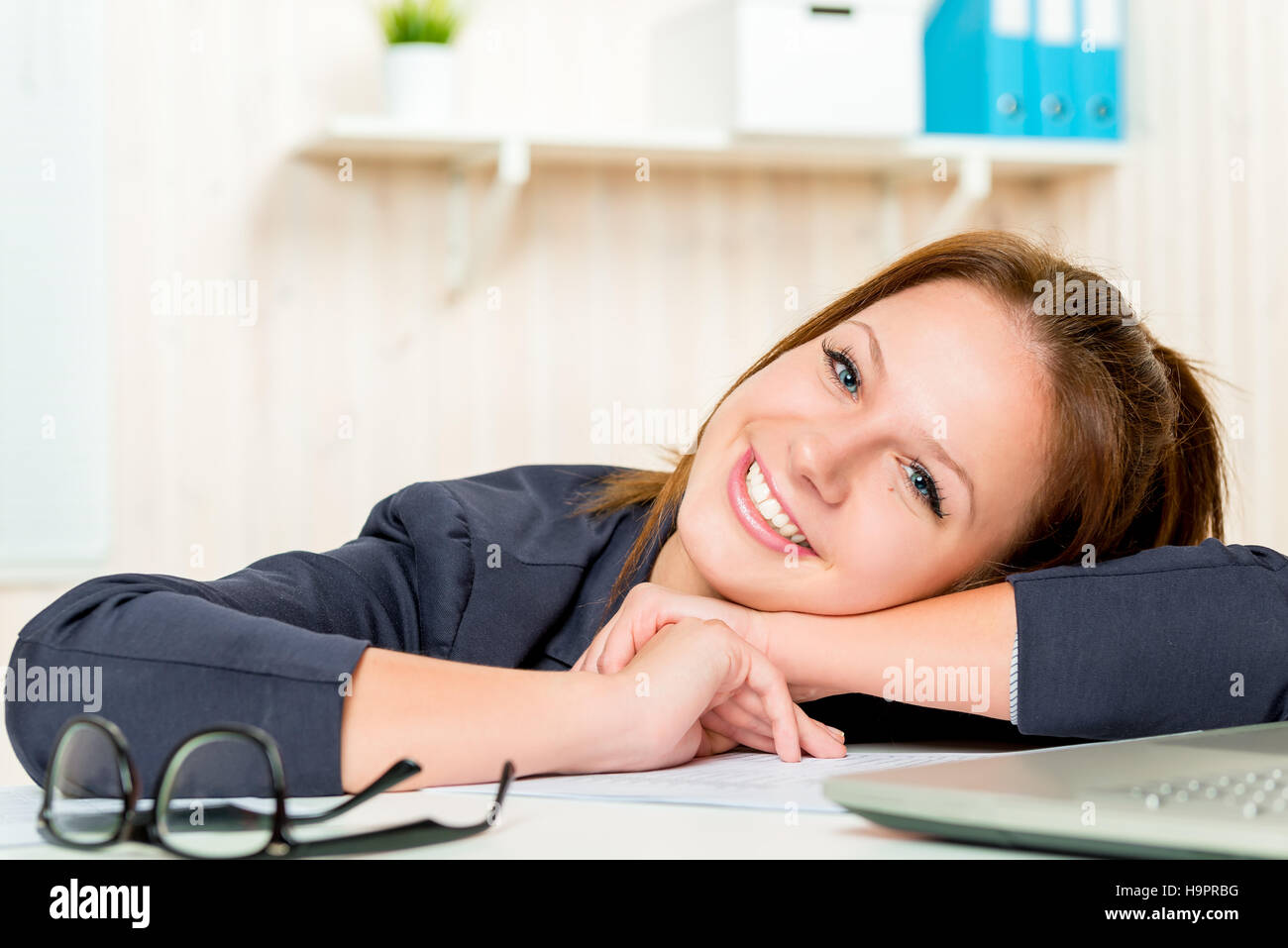 cute young girl posing in an office interior behind table Stock Photo ...