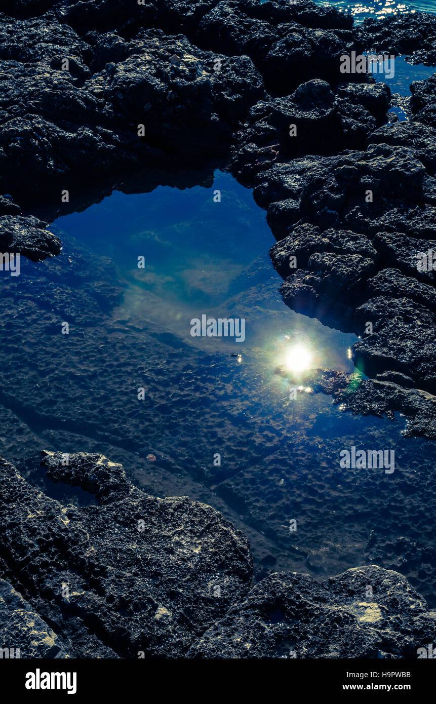 reflection of sun in water in rocks Stock Photo - Alamy
