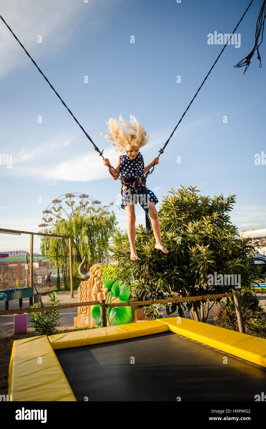 cute child jumping in bungee attraction Stock Photo - Alamy