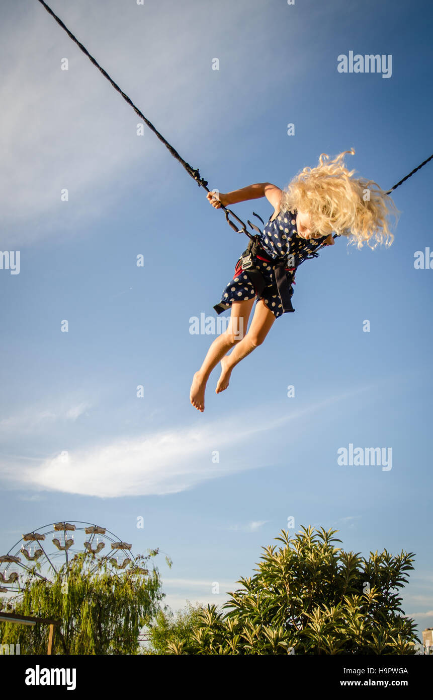 cute child jumping in bungee attraction Stock Photo - Alamy