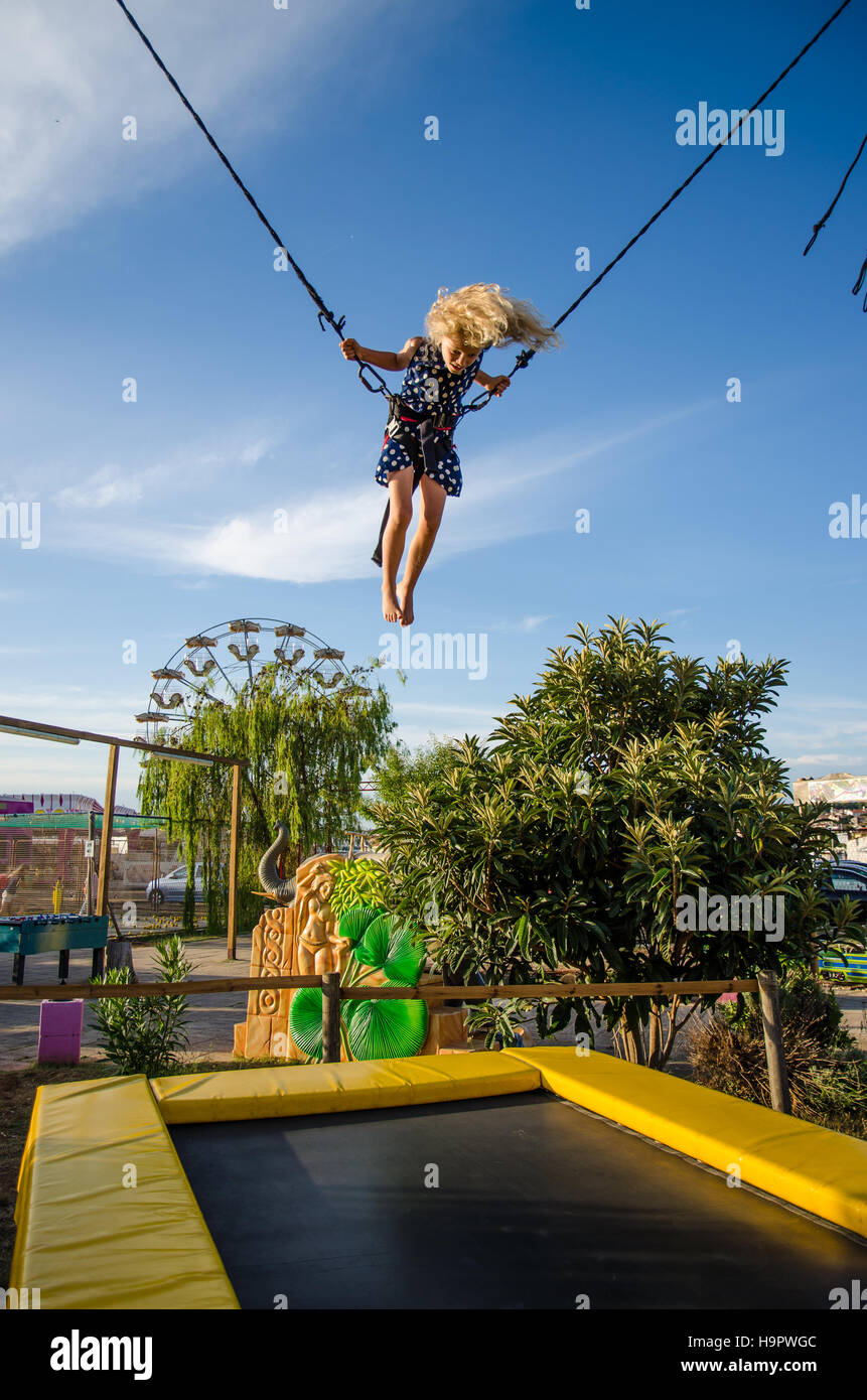 cute child enjoying jumping in bungee attraction Stock Photo - Alamy