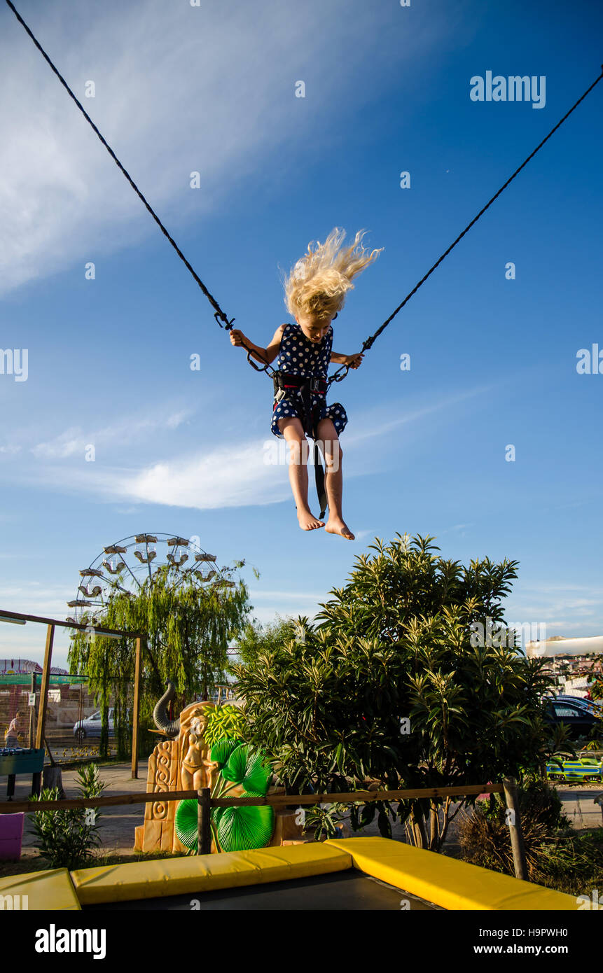 little girl jumping in the bungee attraction Stock Photo - Alamy