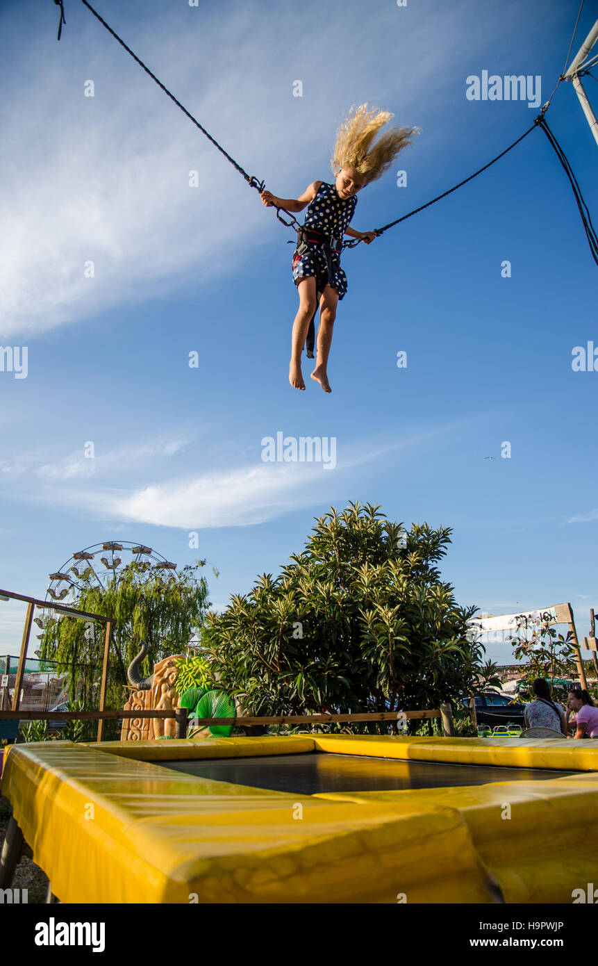 little brave kid jumping in bungee attraction Stock Photo - Alamy
