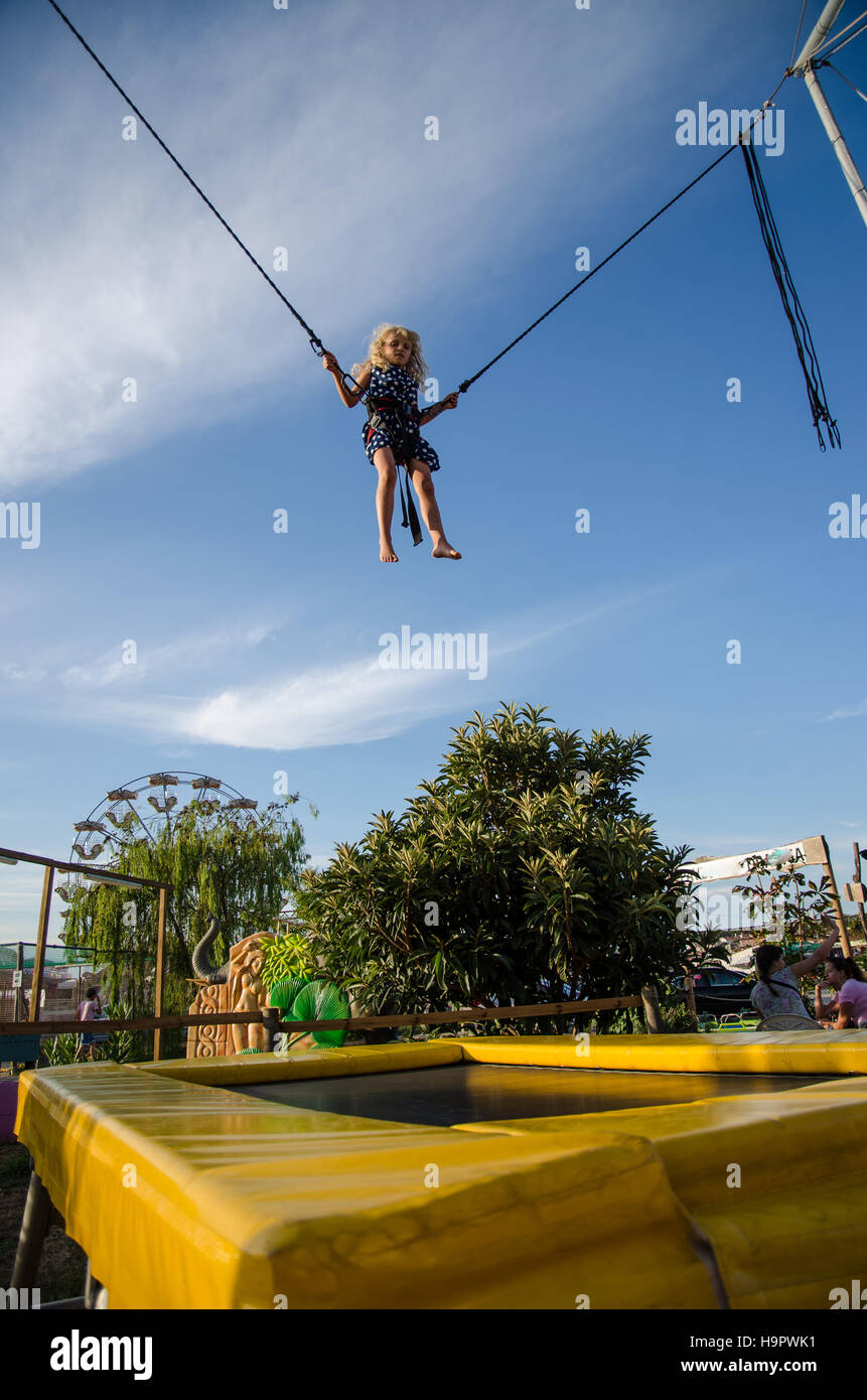 little brave kid jumping in bungee attraction Stock Photo - Alamy