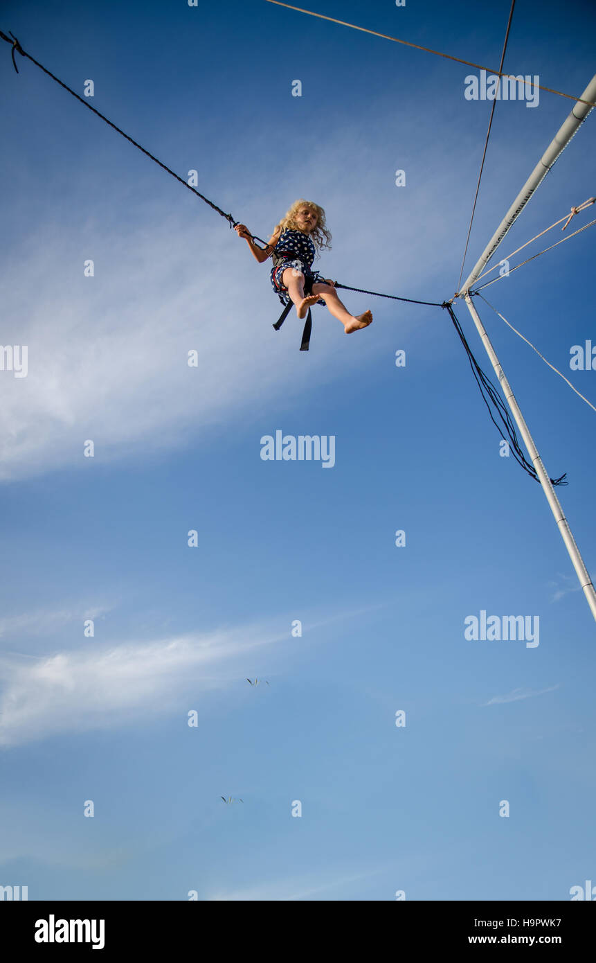 little brave kid jumping in bungee attraction Stock Photo - Alamy