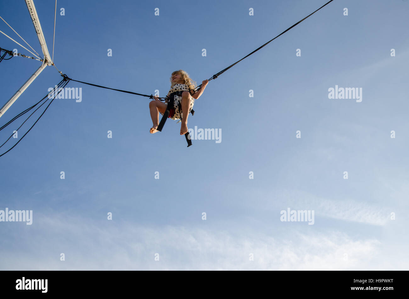 little courageous kid jumping in bungee attraction Stock Photo - Alamy