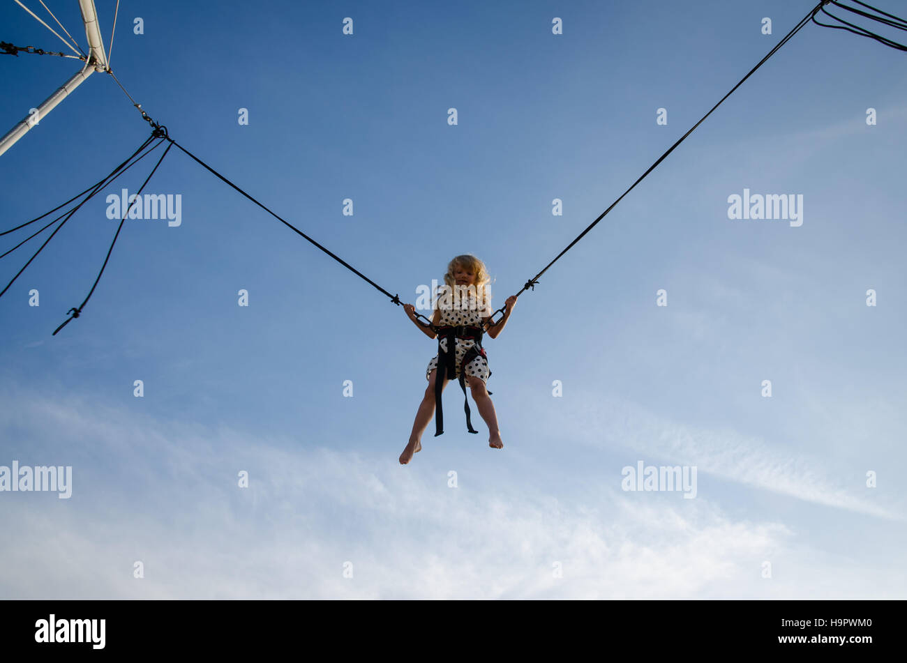 little courageous kid jumping in bungee attraction Stock Photo - Alamy