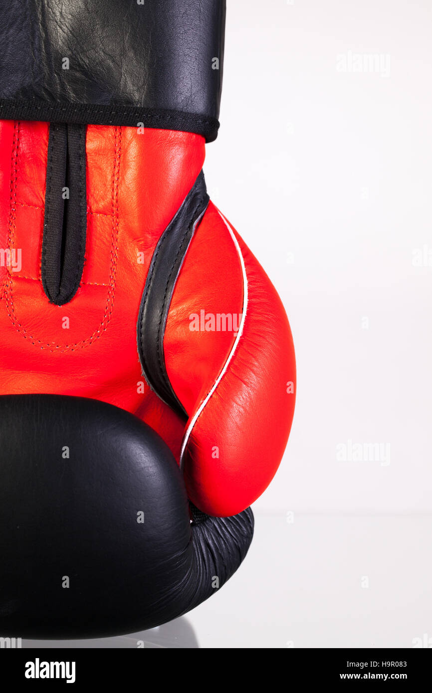 Red and black boxing gloves on a glass table isolated on white ...