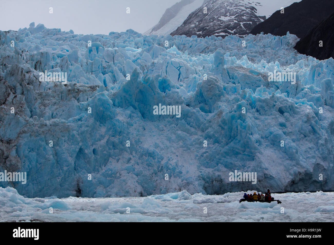 Zodiac with ecotourists exploring a glacier in Garibaldi fjord in ...