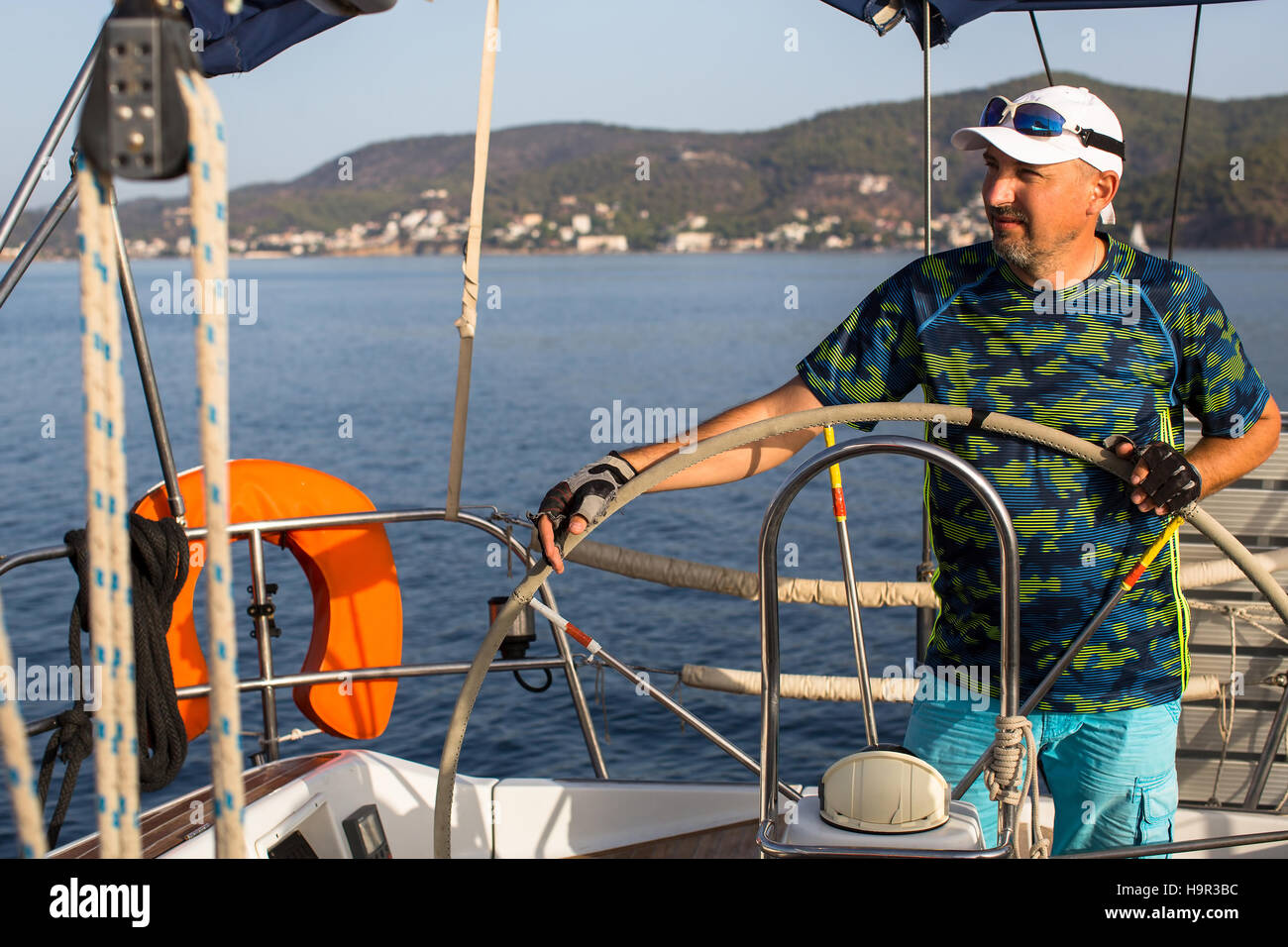 A man stands at the helm and operates the sailing vessel Stock Photo ...