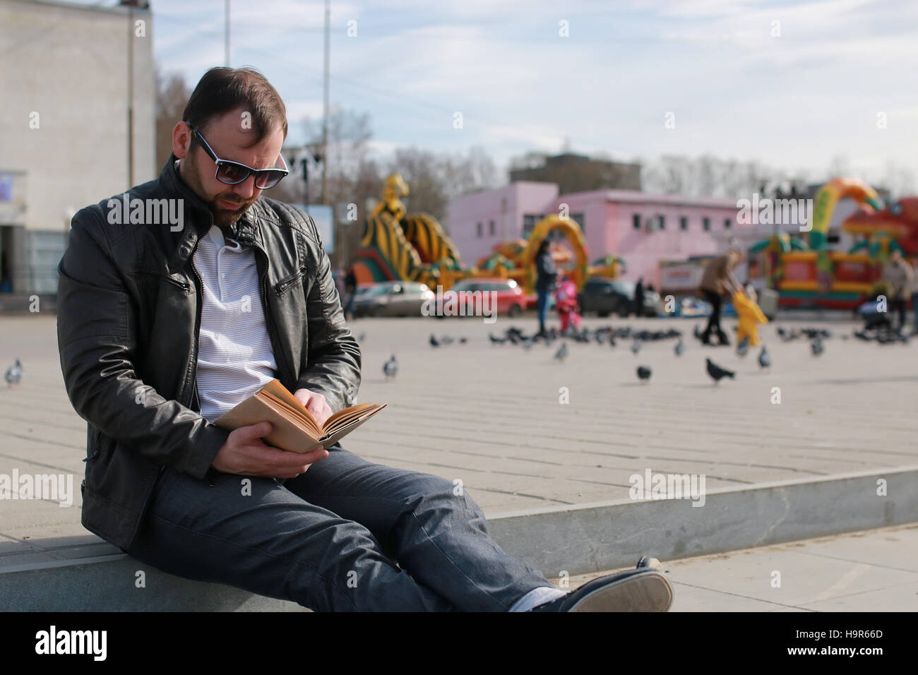 man in jacket and street read book Stock Photo - Alamy