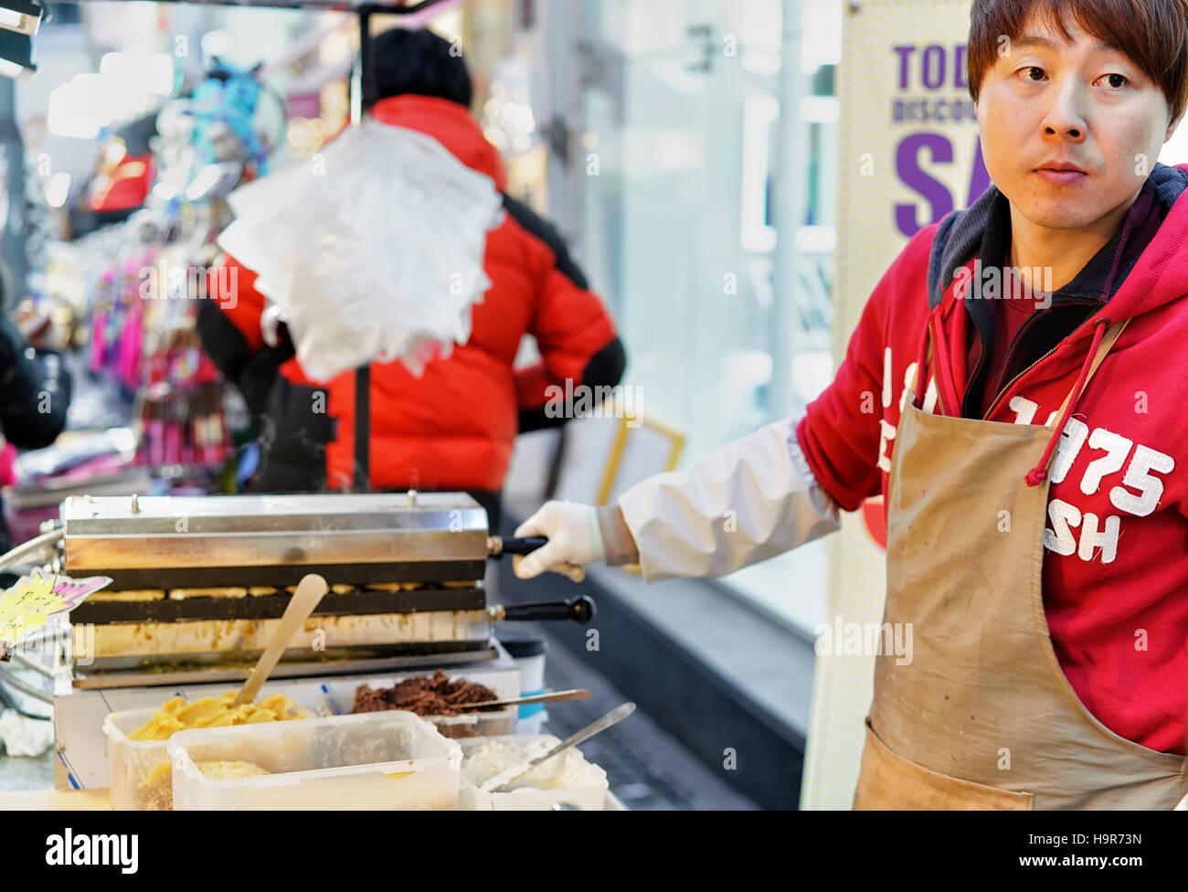 Seoul, South Korea - March 14, 2016: Seller of waffles is cooking one ...