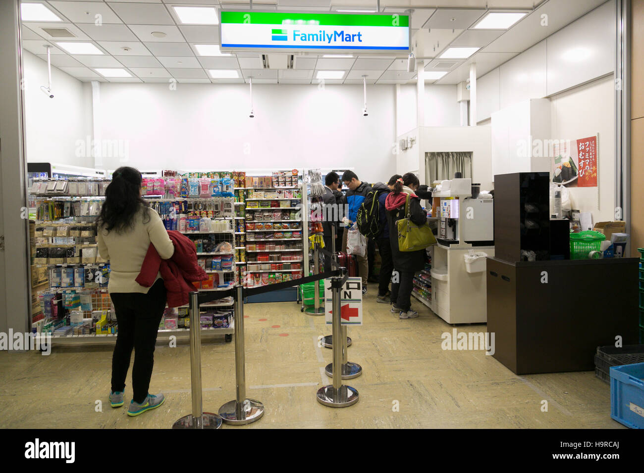 Travelers buy products at a new FamilyMart convenience store in ...