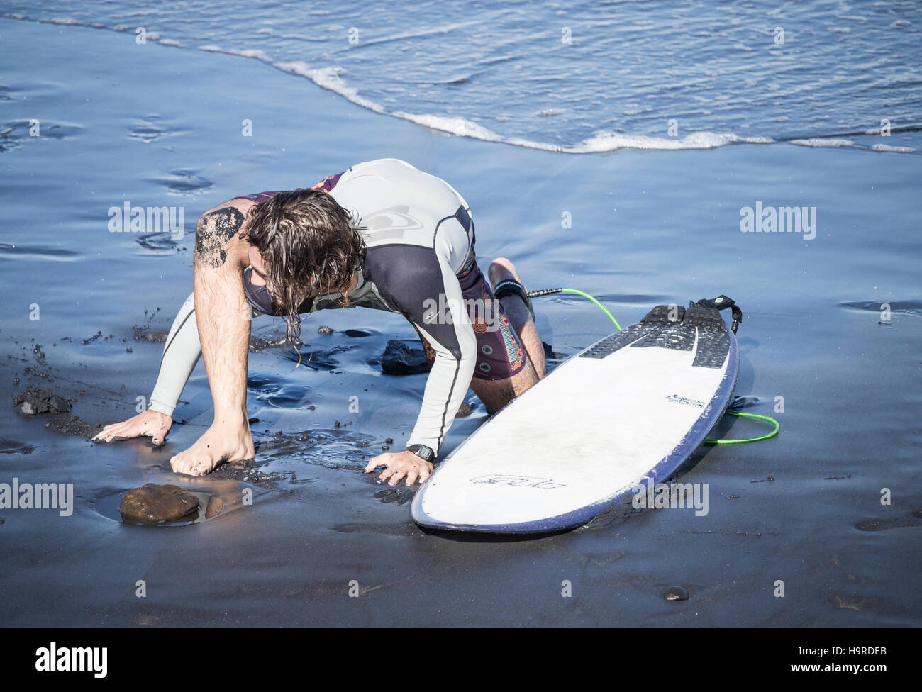 Surfer stretching on beach Stock Photo - Alamy