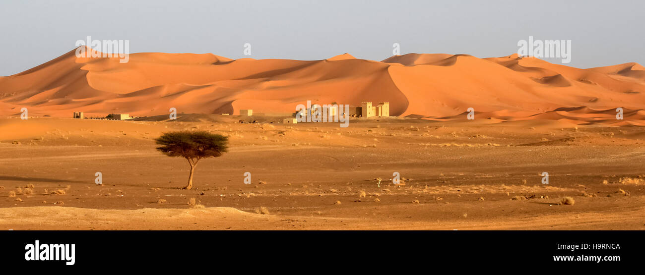Berber homes at the foot of gigantic and stunning sand dunes of Sahara ...