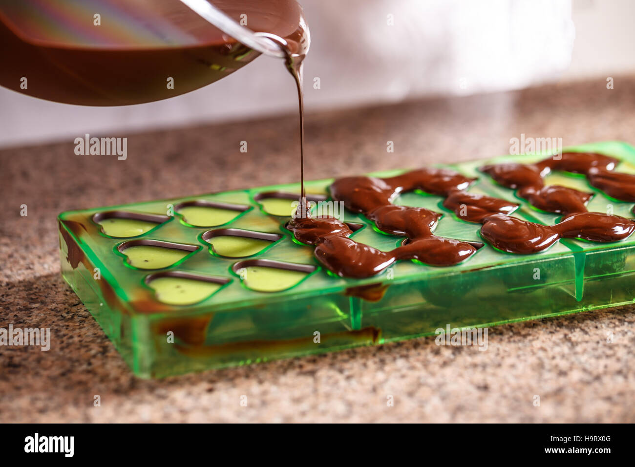 Pouring chocolate in mold Stock Photo - Alamy