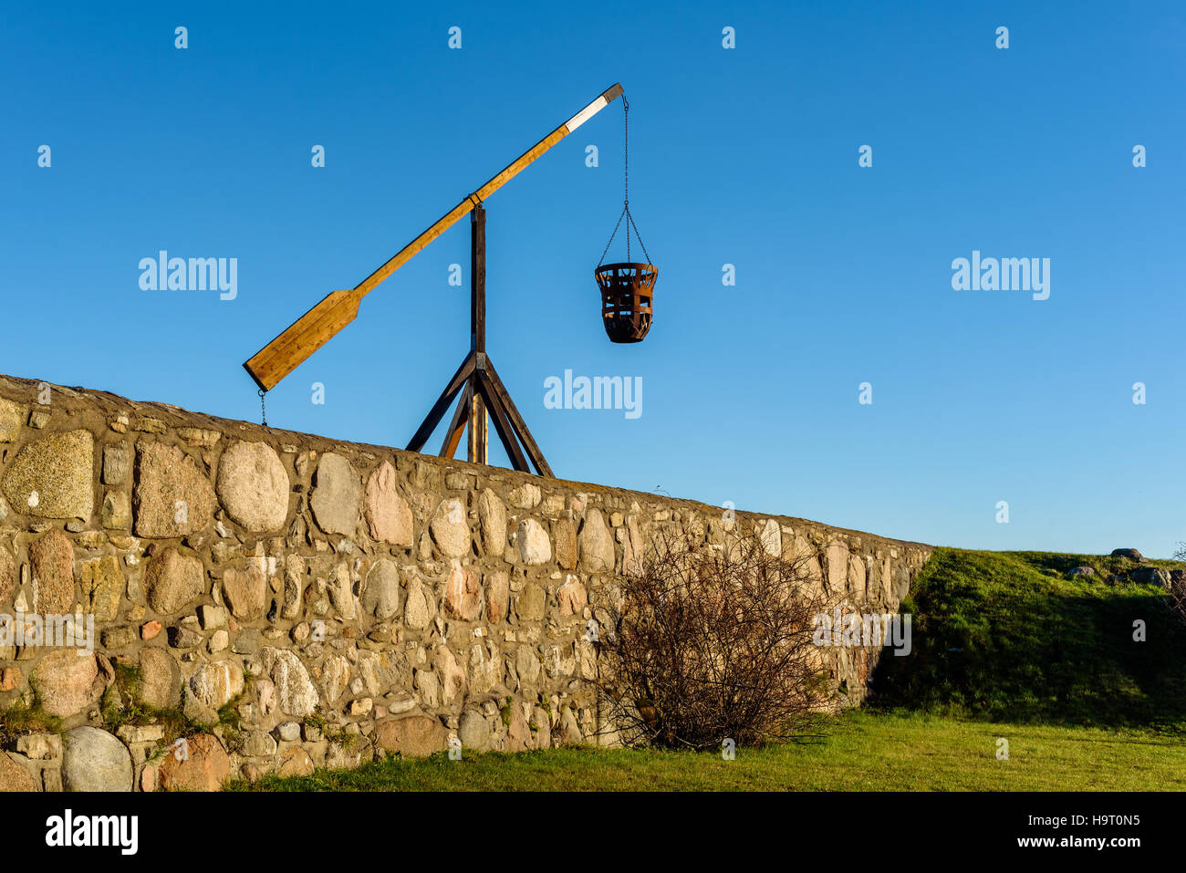 Old wood fire beacon at the end of a large stone wall Stock Photo - Alamy