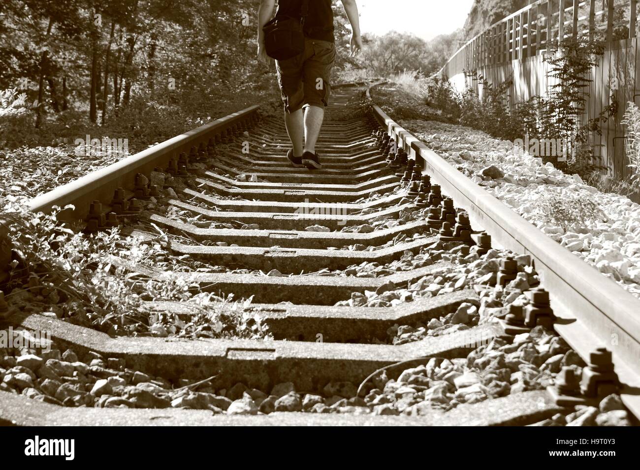 Man walking on rail. Cropped body Stock Photo - Alamy