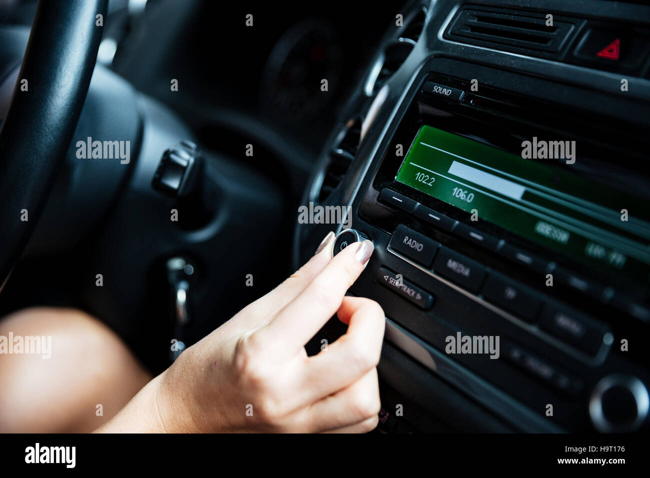 Cropped image of a woman hand turning button of radio in car Stock ...