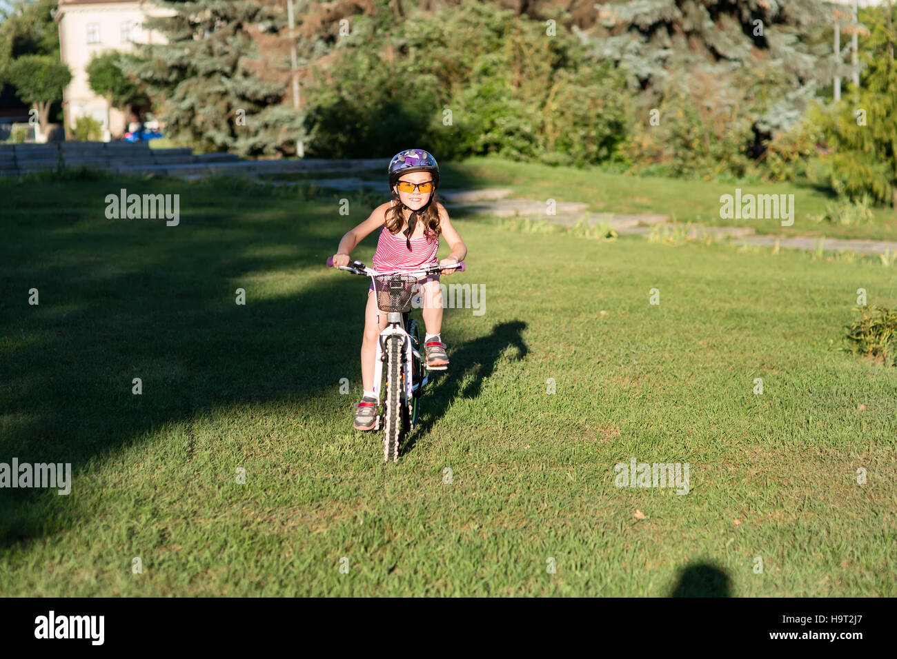 happy child girl riding bicycle in summer sunset in the park. Active kids Stock Photo - Alamy