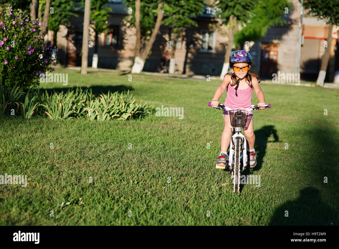happy child girl riding bicycle in summer sunset in the park. Active kids Stock Photo - Alamy