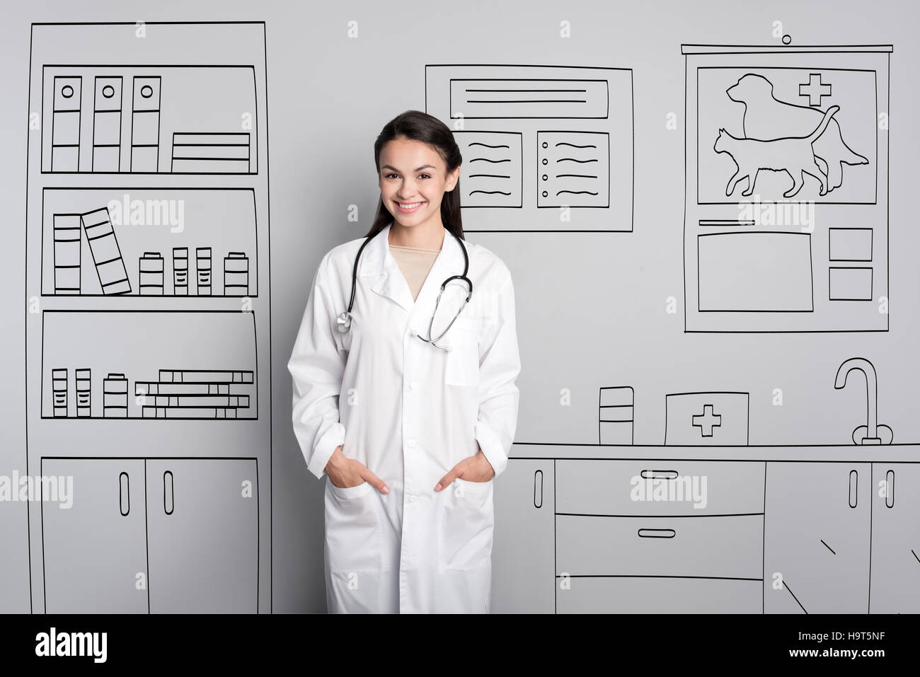 Beautiful doctor posing on a grey background Stock Photo - Alamy