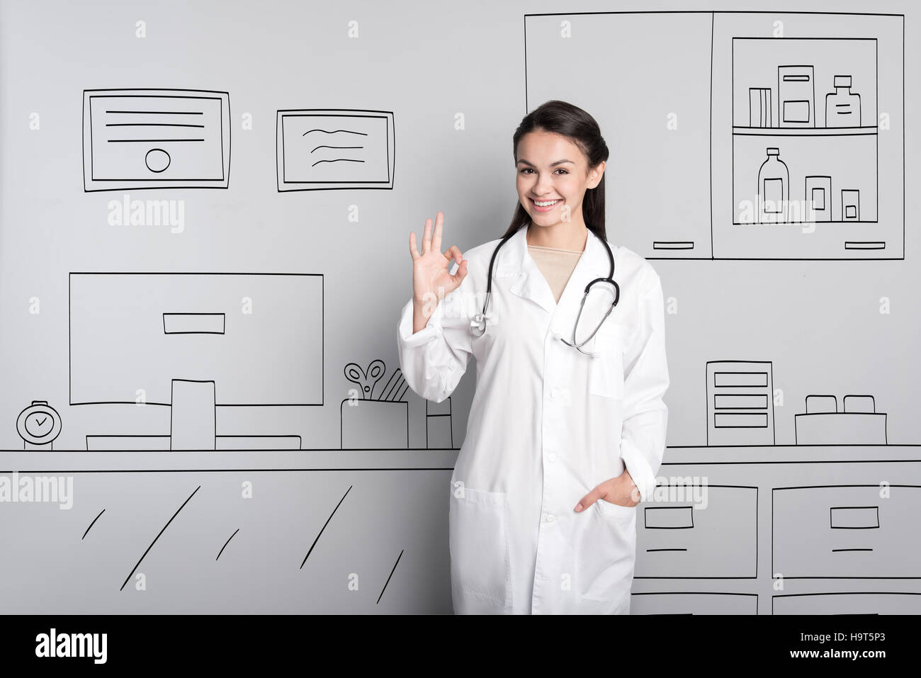 Pretty doctor making an okay gesture Stock Photo - Alamy