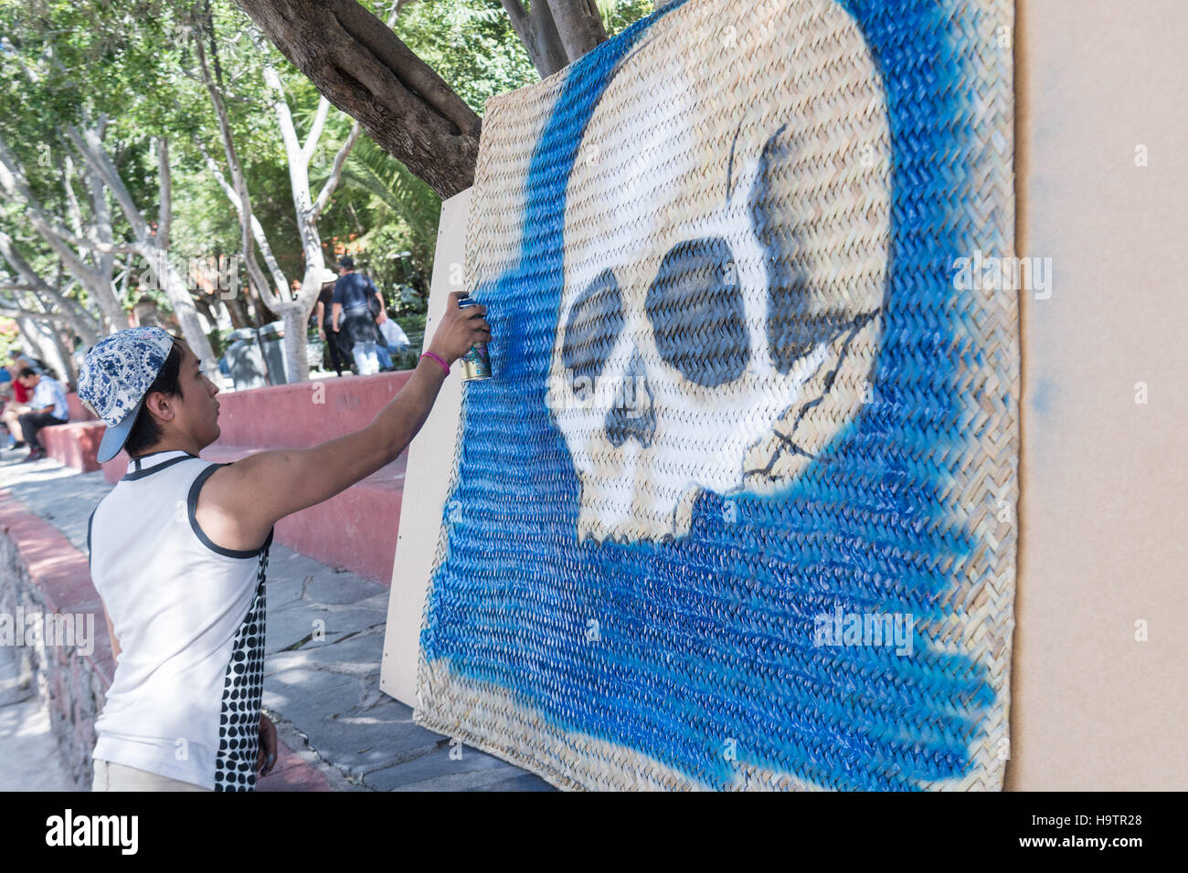 A Mexican graffiti artist paints a skull for Day of the Dead festival ...