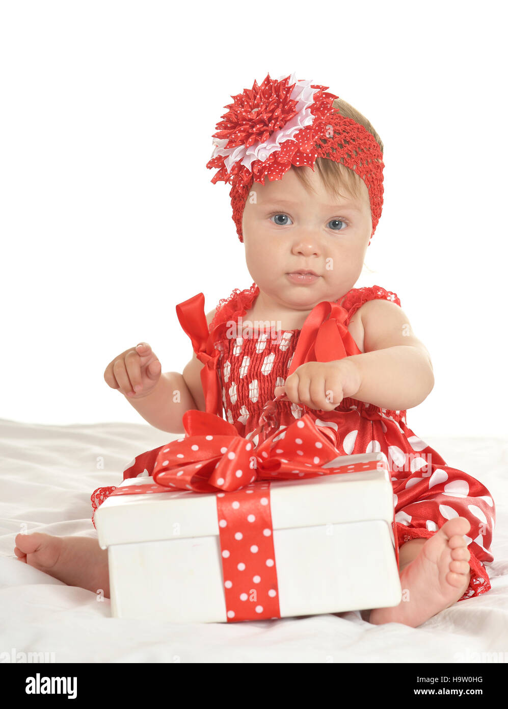 Baby girl in dress with gift Stock Photo - Alamy