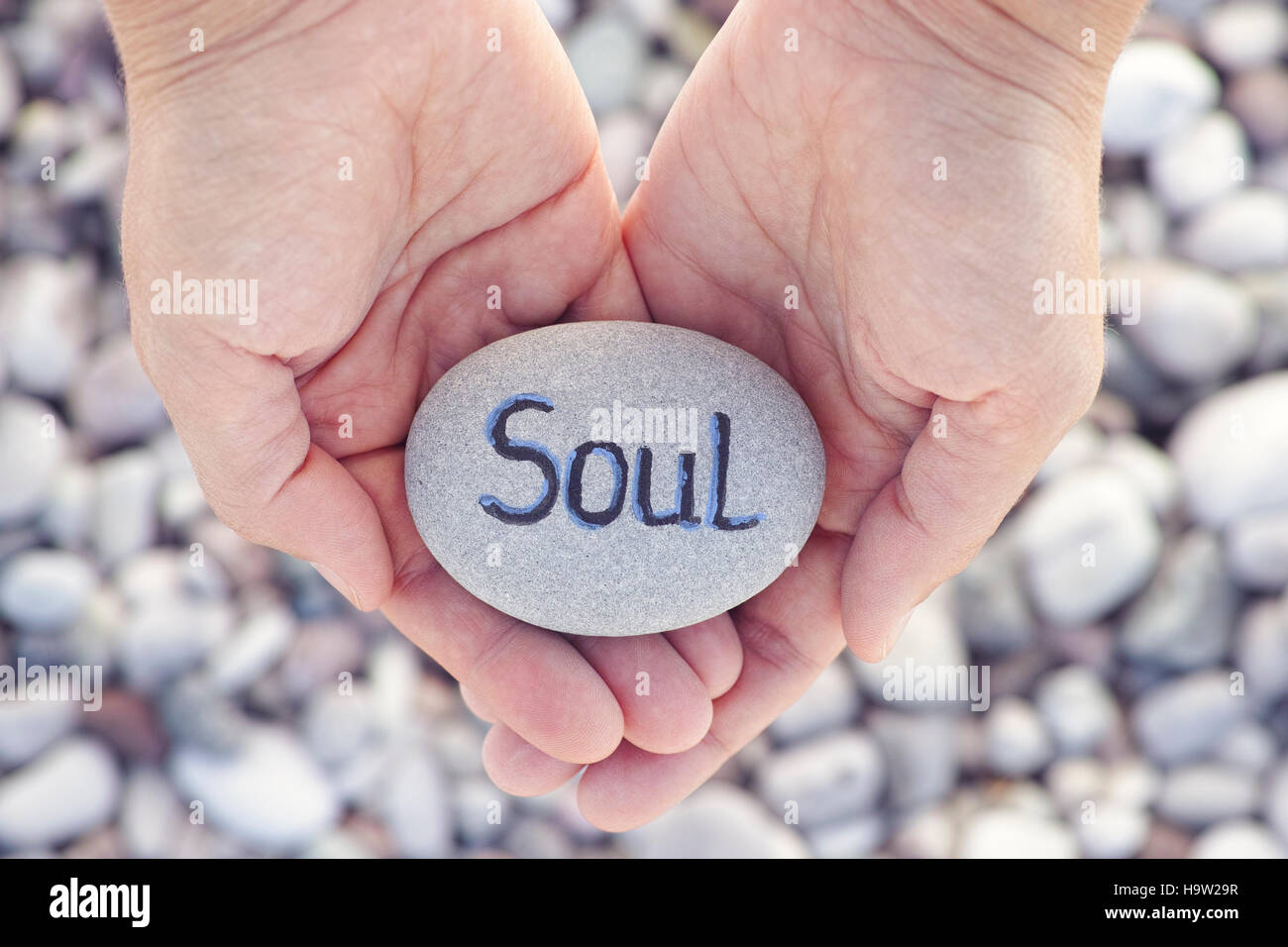 Soul. Woman holding stone with the word Soul in her palms. Close up ...