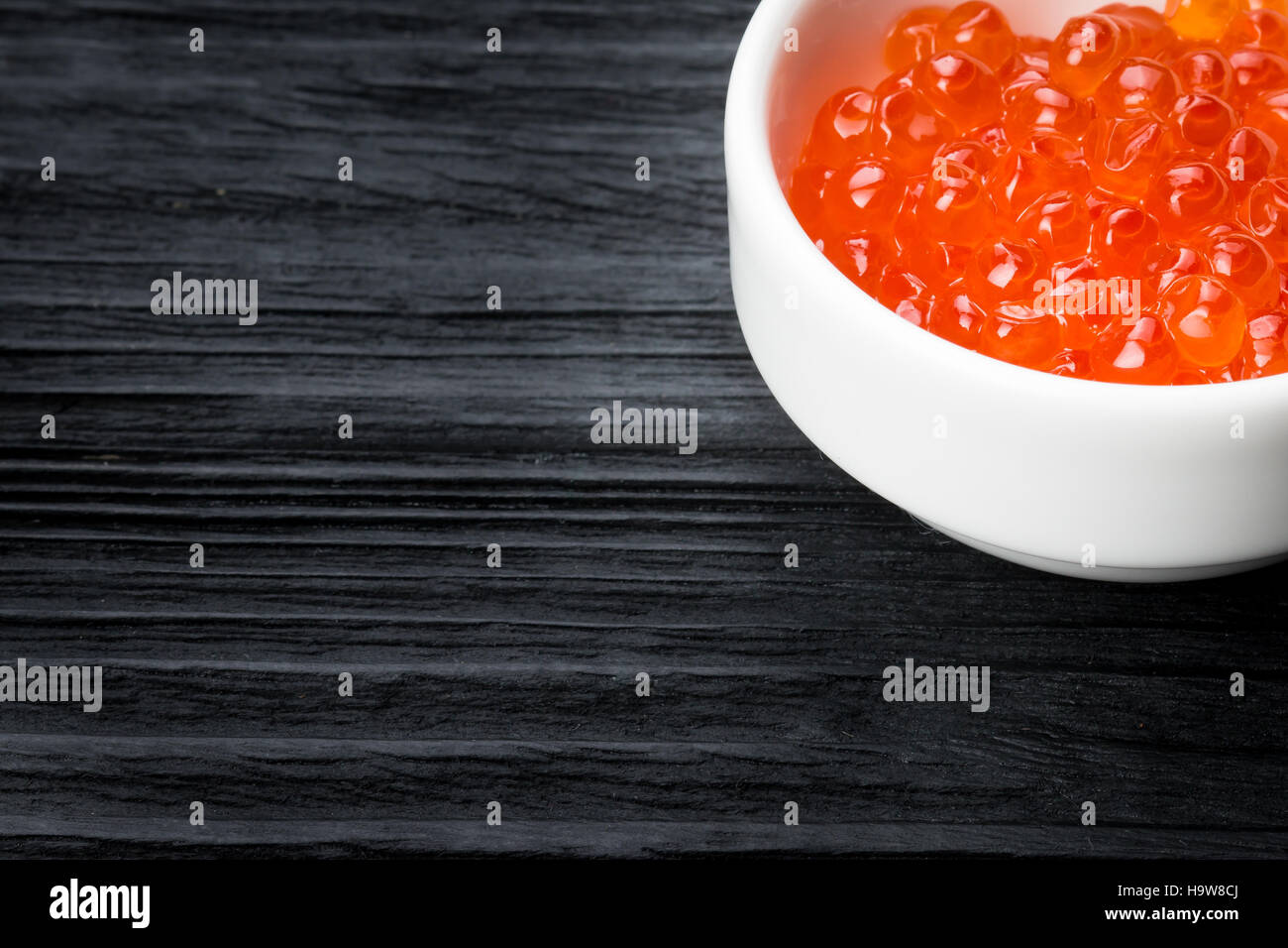 Red caviar in a cup with salt on a wooden background Stock Photo - Alamy